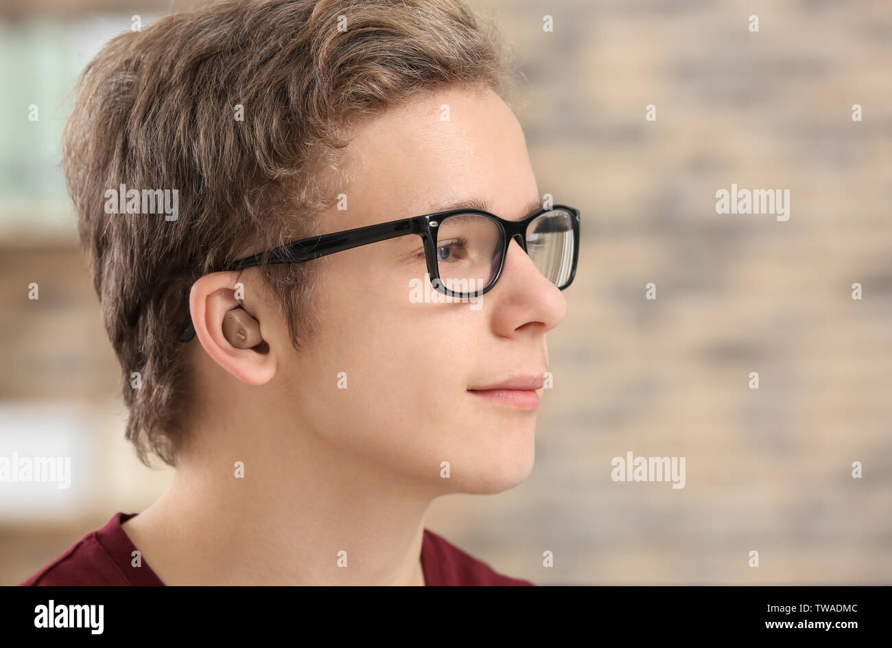 Teenage boy with hearing aid indoors Stock Photo - Alamy