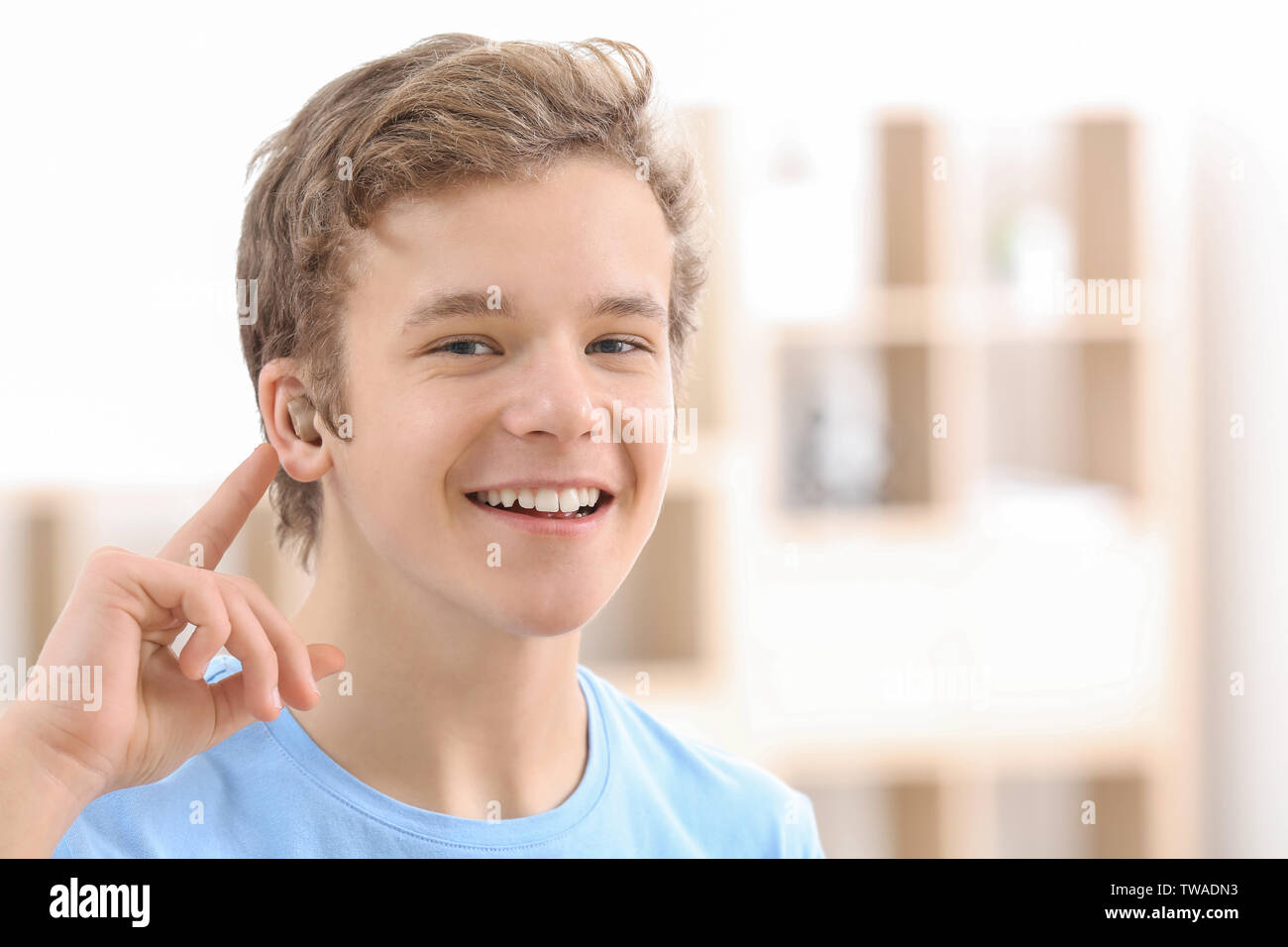 Teenage boy with hearing aid indoors Stock Photo - Alamy