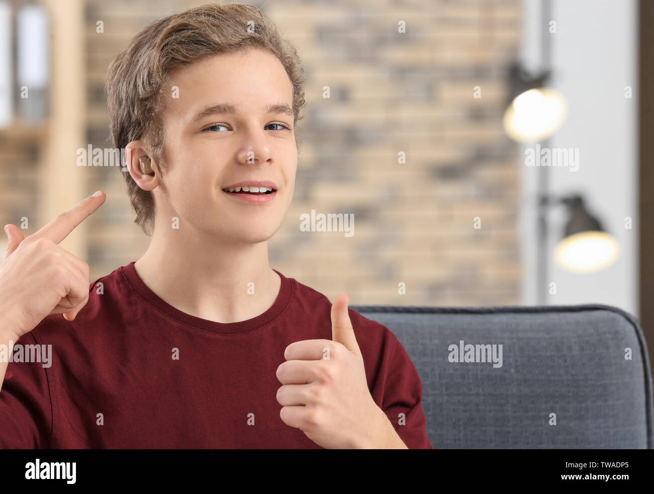 Teenage boy with hearing aid indoors Stock Photo - Alamy