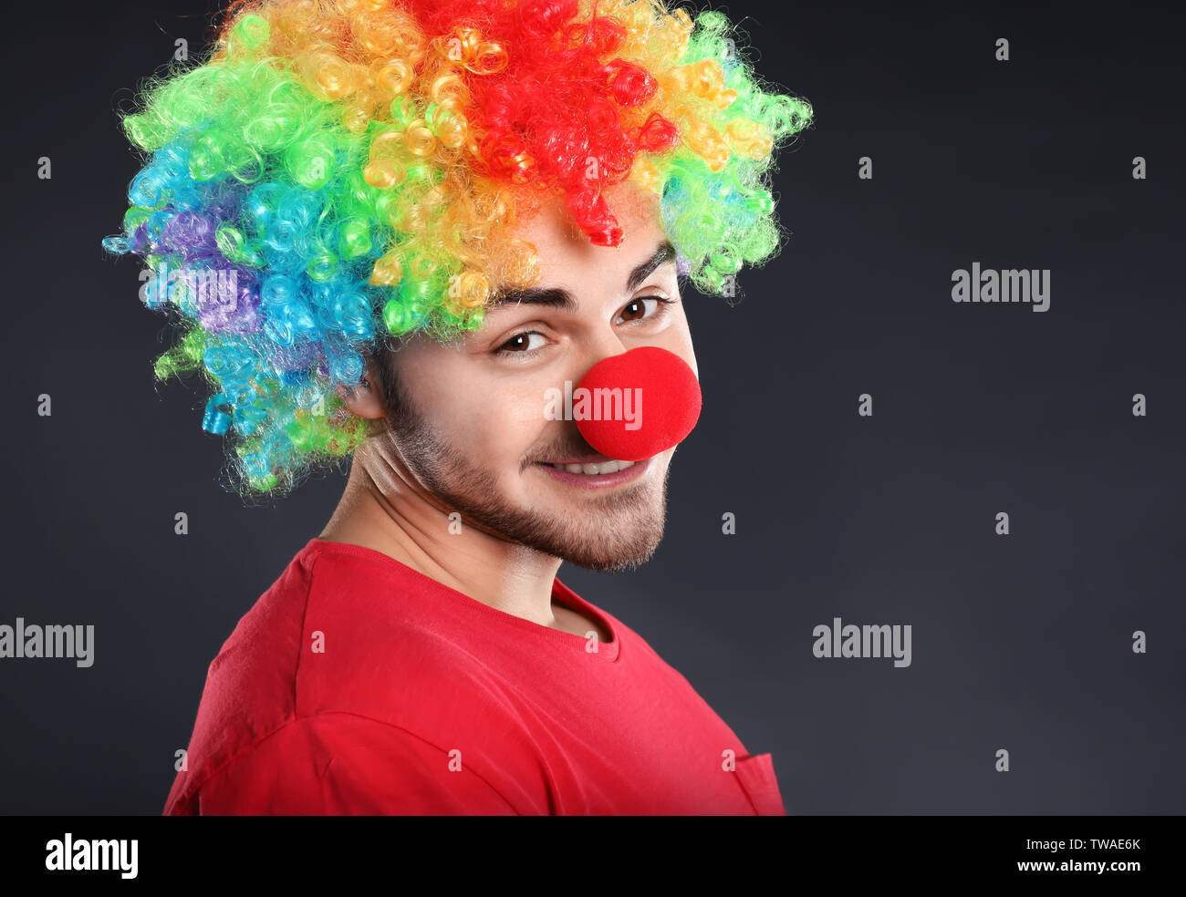 Young man in funny disguise on grey background. April fool's day ...