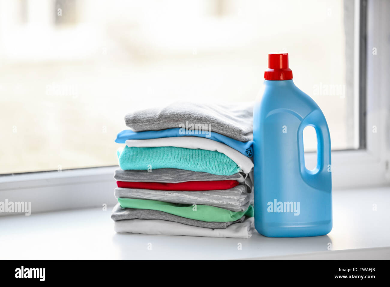 Stack of clothes and laundry detergent on windowsill Stock Photo - Alamy