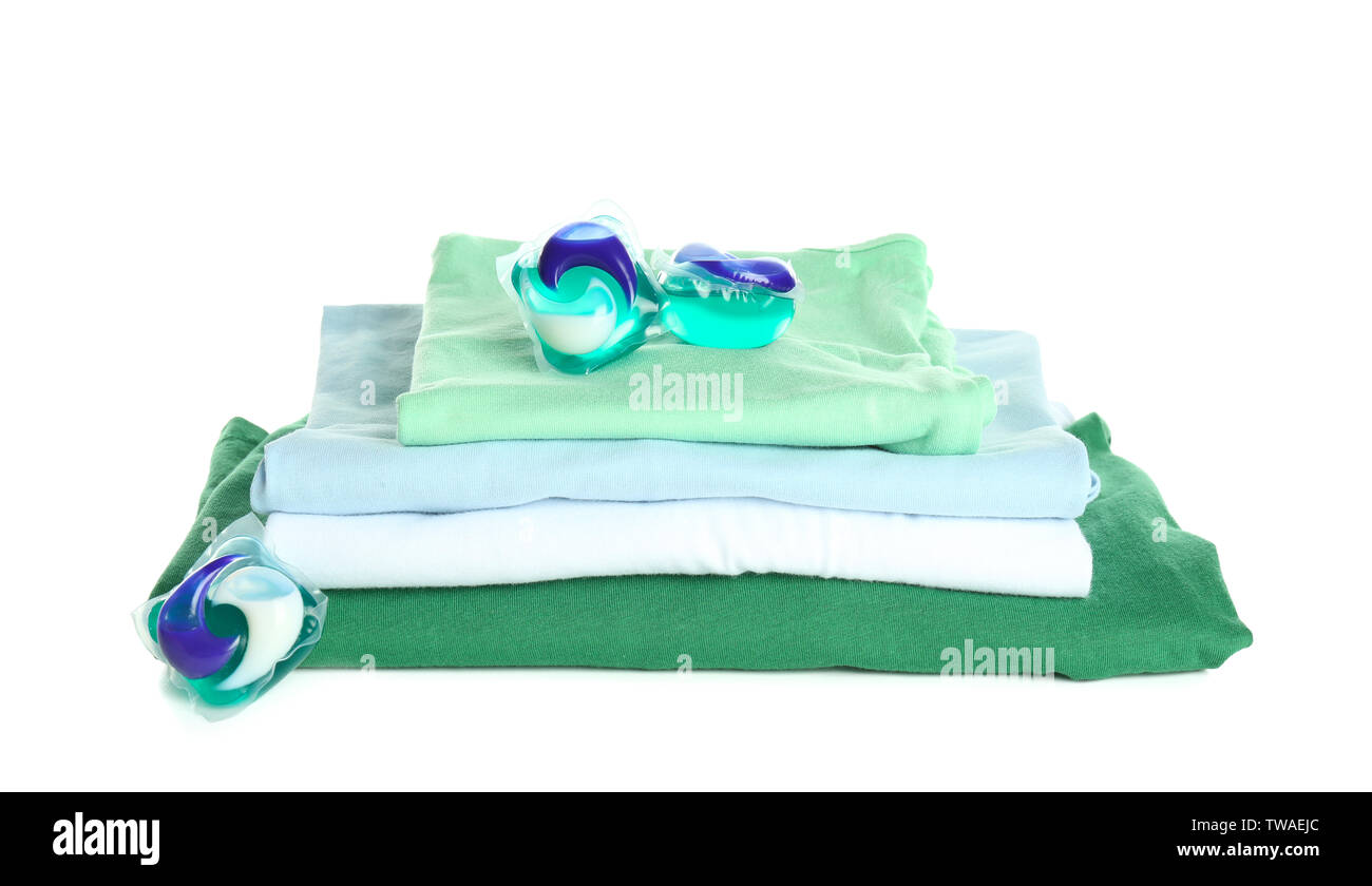 Stack of clothes and laundry pods on white background Stock Photo - Alamy