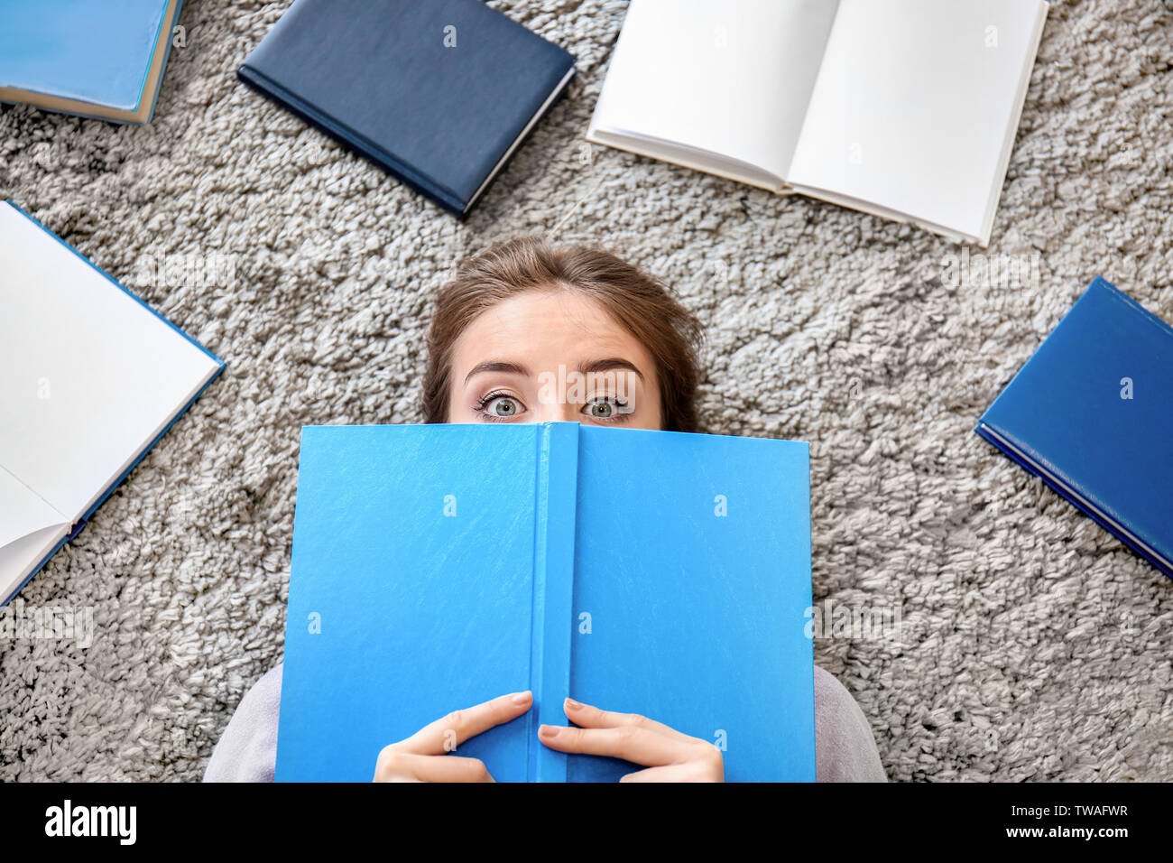 Female student reading books at home Stock Photo - Alamy