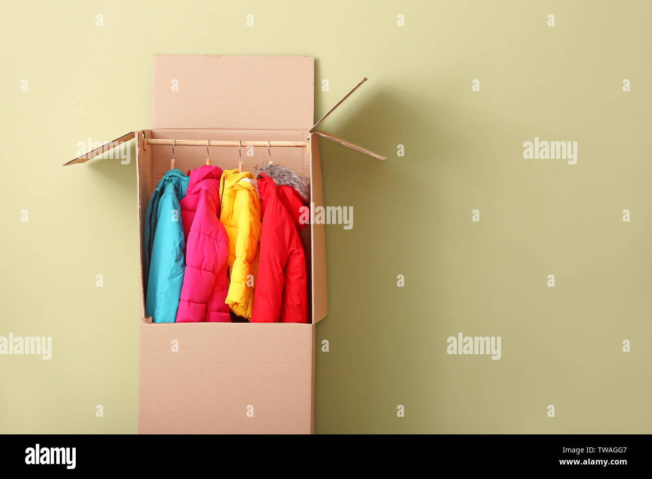 Wardrobe box with clothes on color background Stock Photo - Alamy