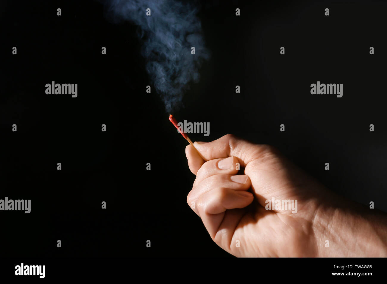 Male hand with match on dark background Stock Photo - Alamy