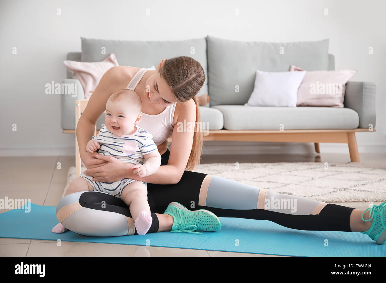 Mother training with cute little baby at home Stock Photo - Alamy