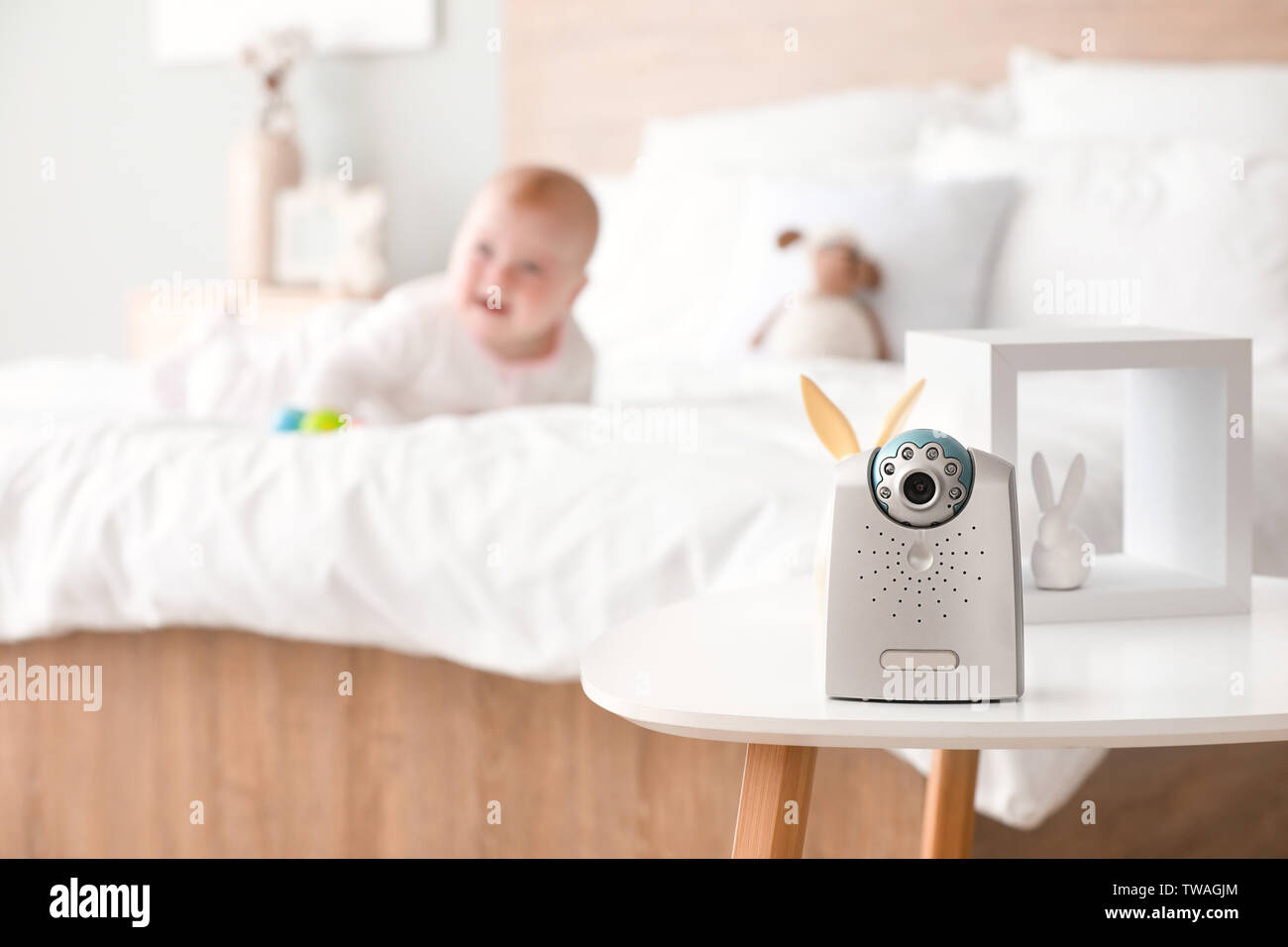 Modern baby monitor on table in room with little child Stock Photo - Alamy