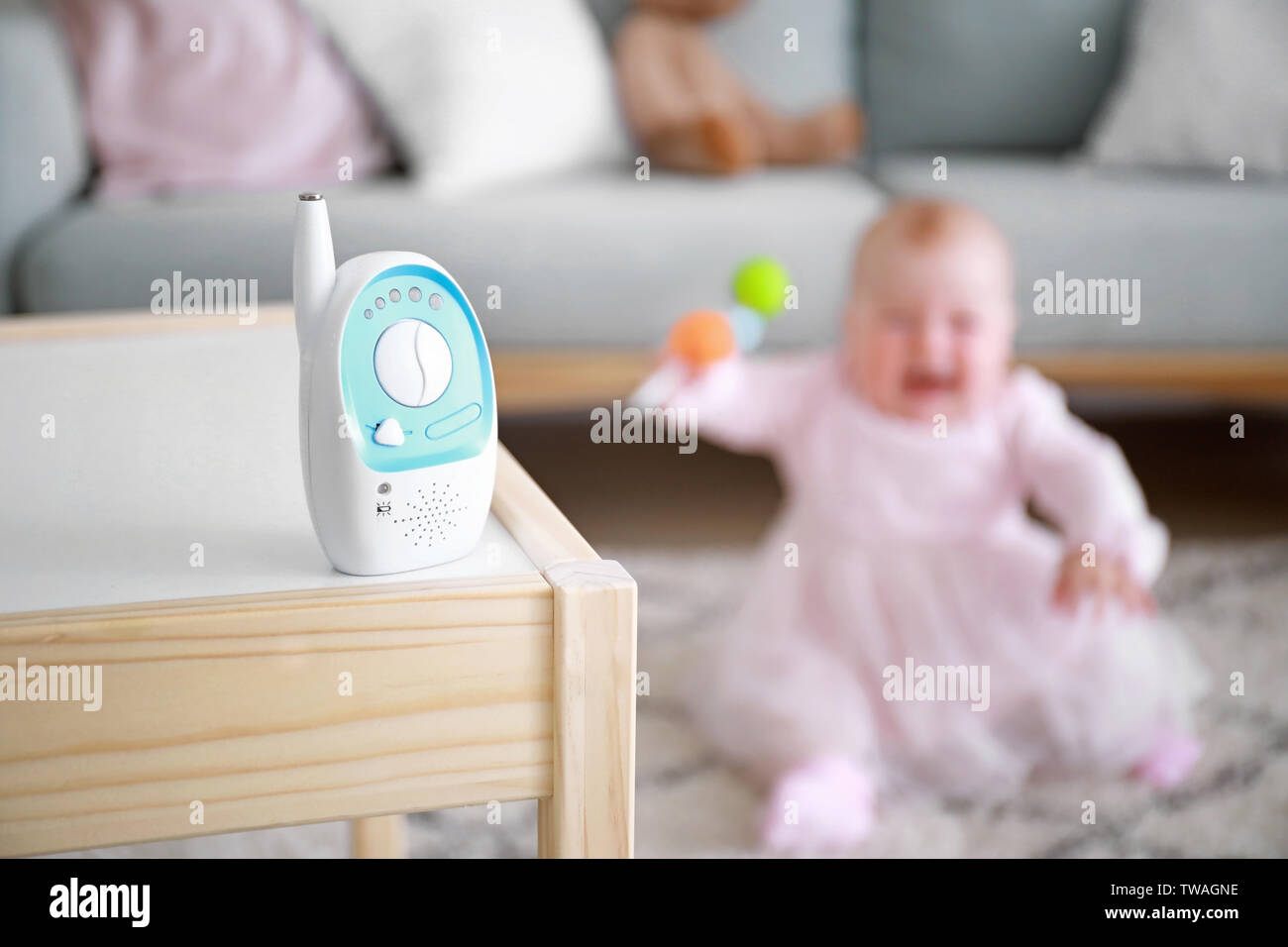 Modern baby monitor on table in room with little child Stock Photo - Alamy