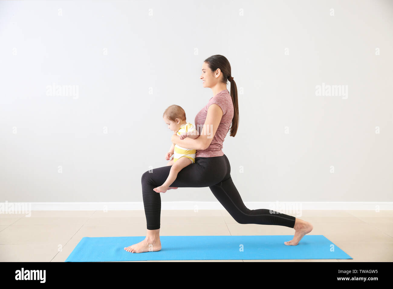 Mother training with cute little baby indoors Stock Photo - Alamy