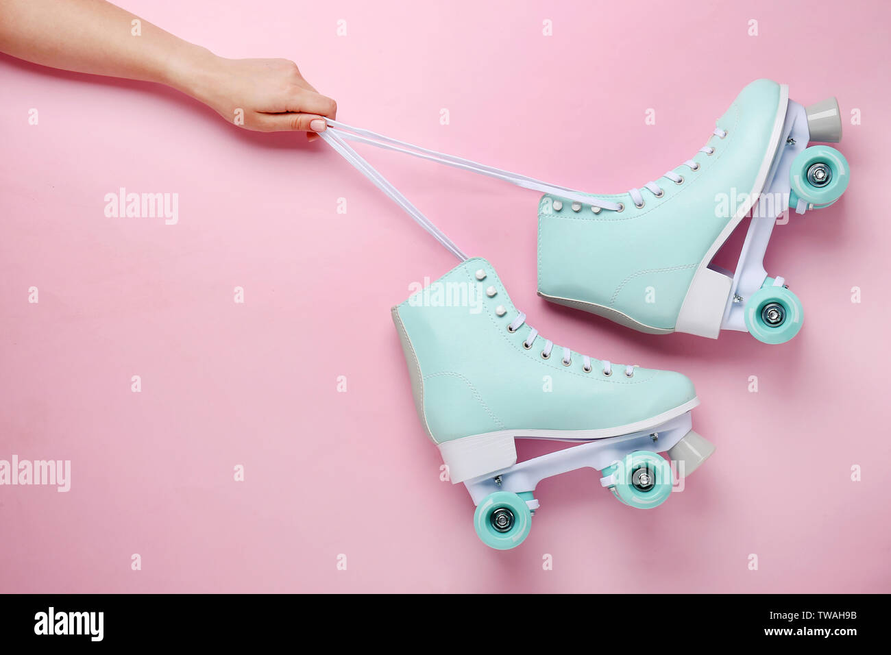 Female hand and vintage roller skates on color background Stock Photo ...