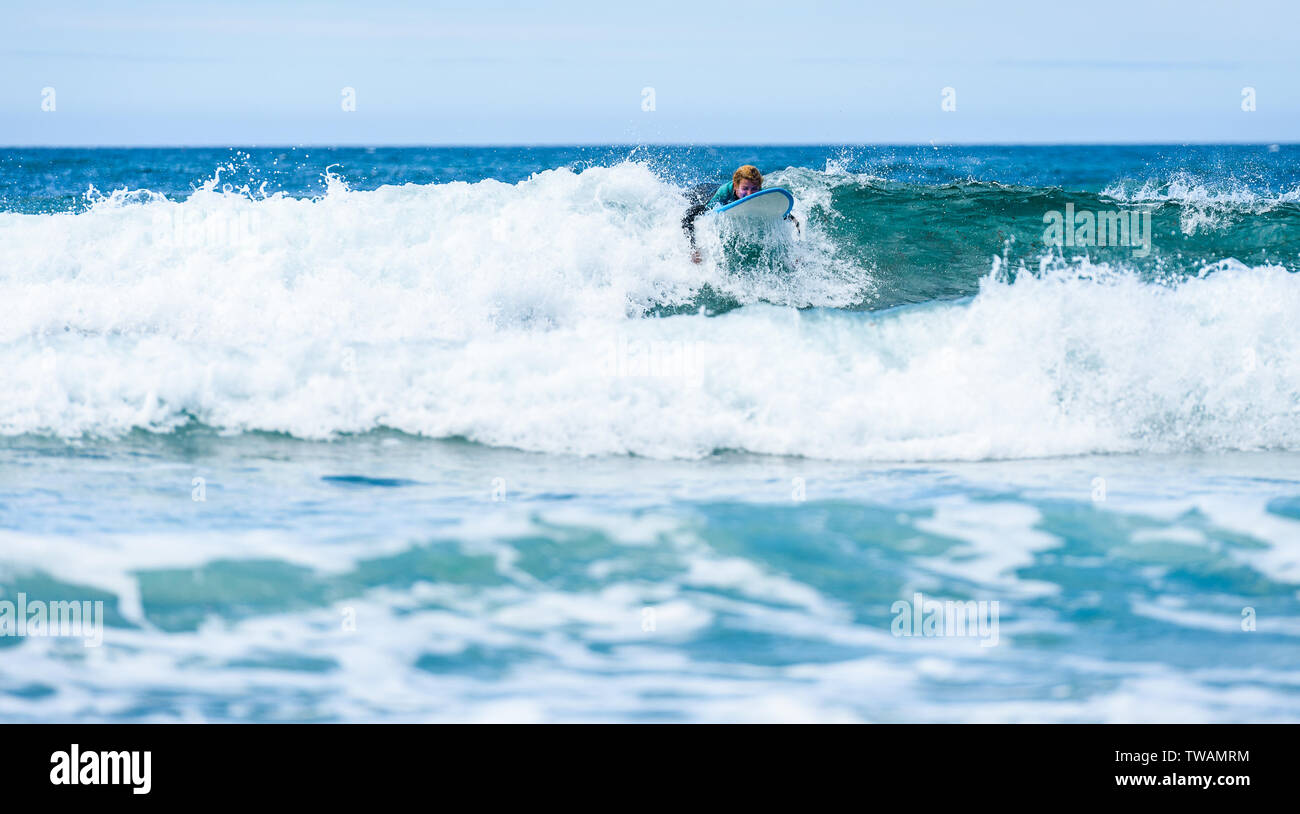 Surfer woman with surfboard is paddling on the wave. Girl in surfing ...