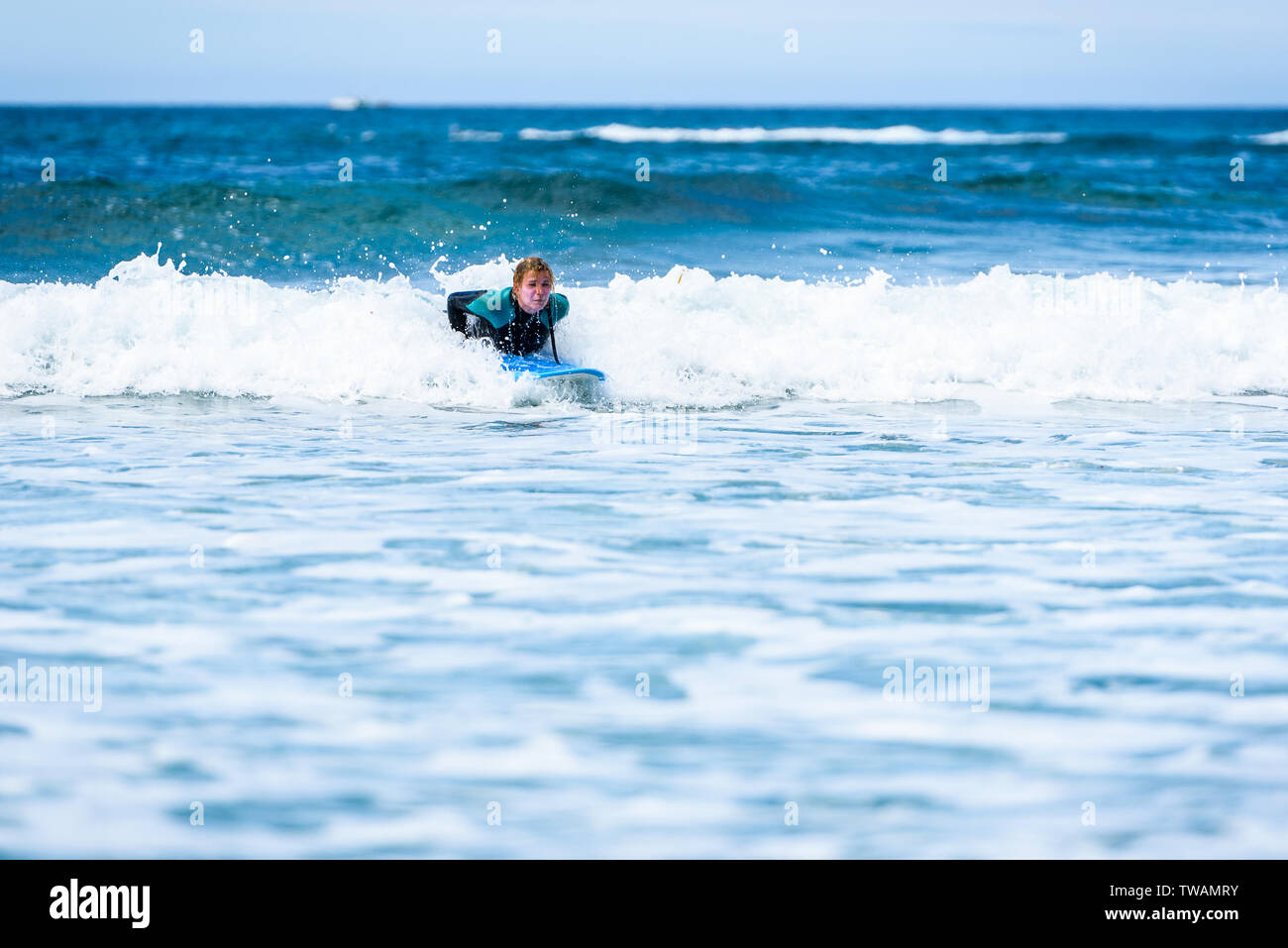 Surfer woman with surfboard is paddling on the wave. Girl in surfing ...