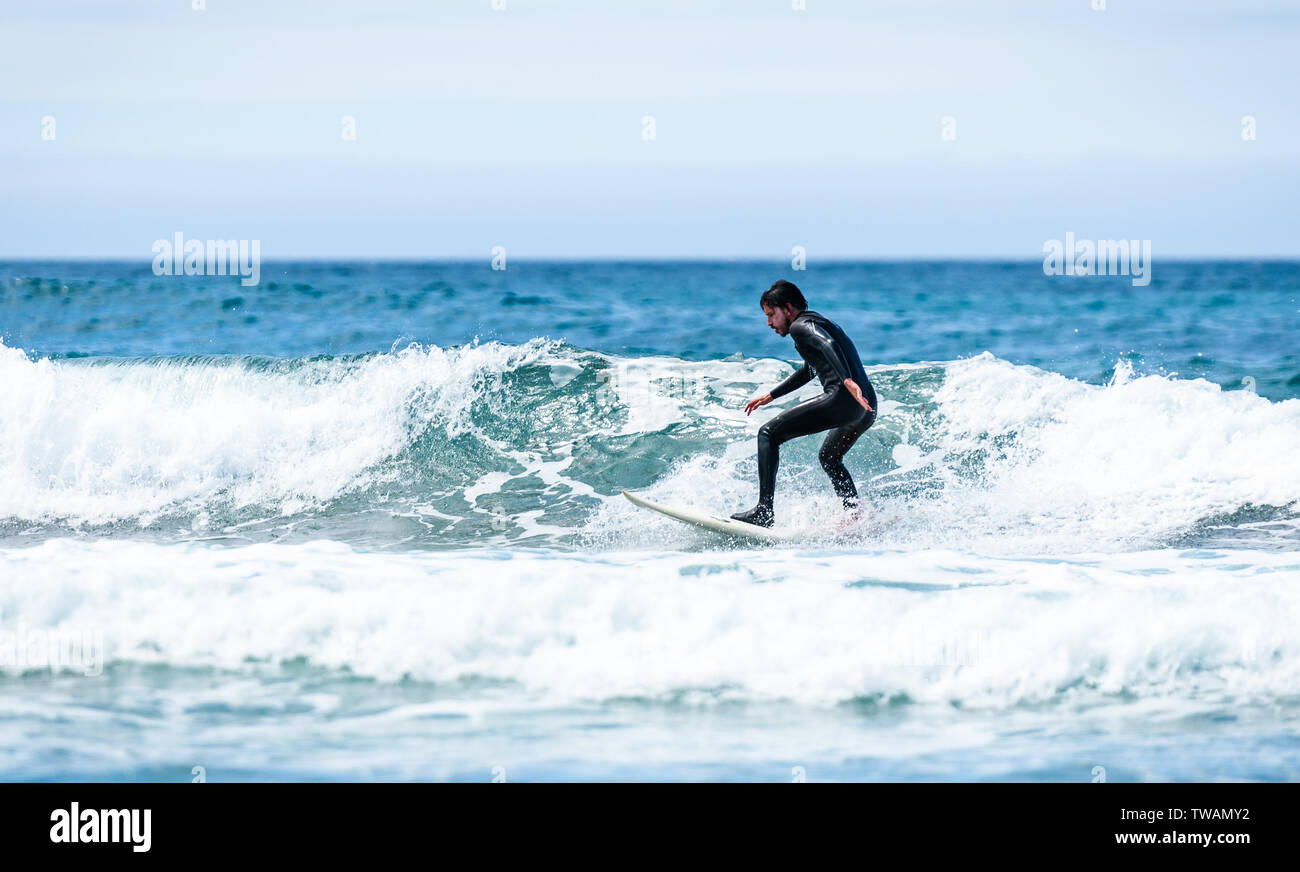 Surfer guy surfing with surfboard on waves in Atlantic ocean. Man in ...