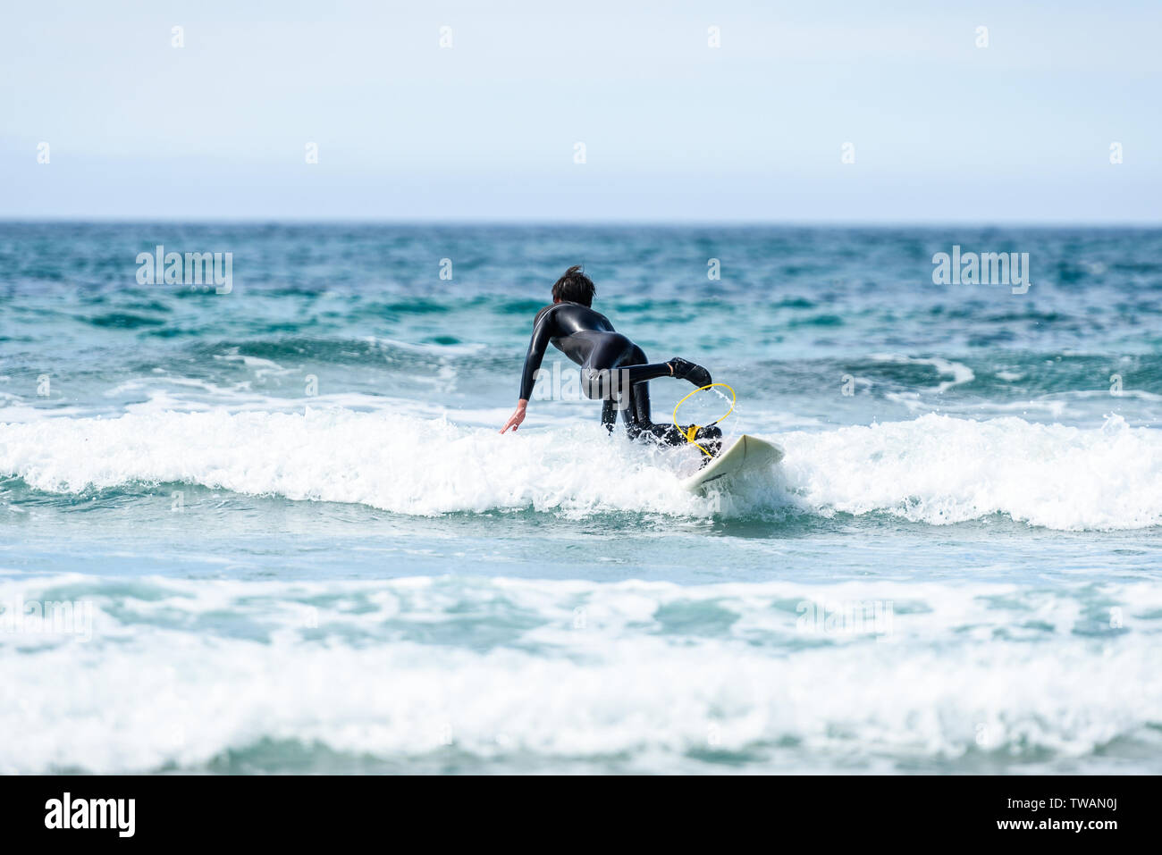 Surfer man with surfboard is falling in water. Guy in surfing wet suit ...
