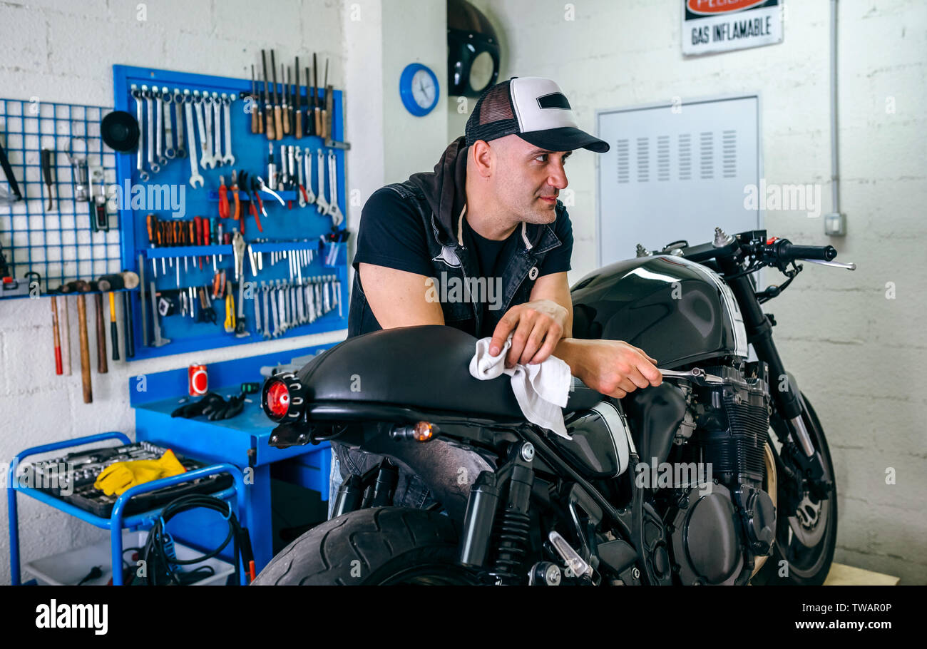 Mechanic posing with a motorcycle Stock Photo - Alamy