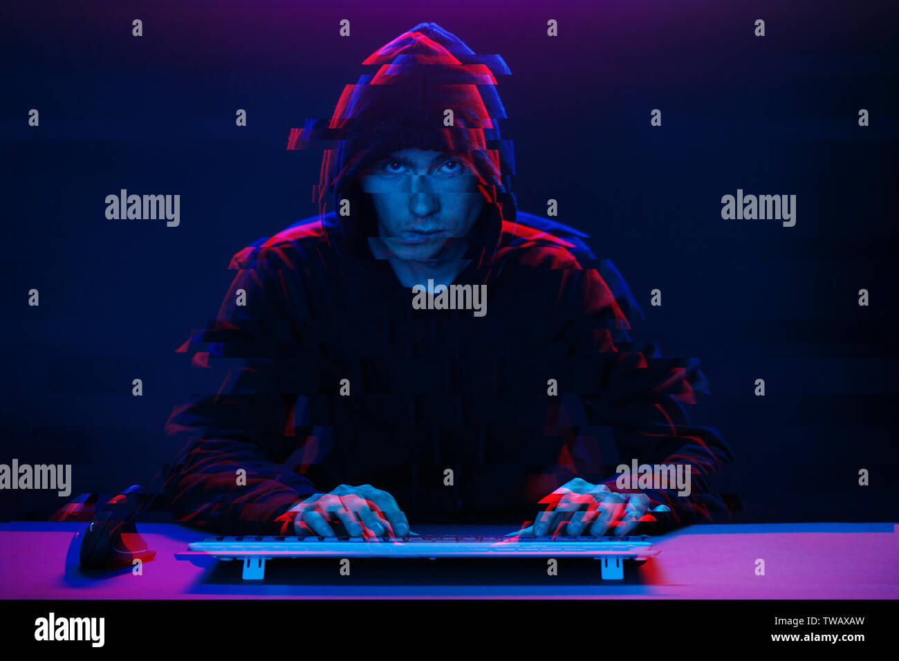 Hacker in the hood working with computer typing text in dark room ...