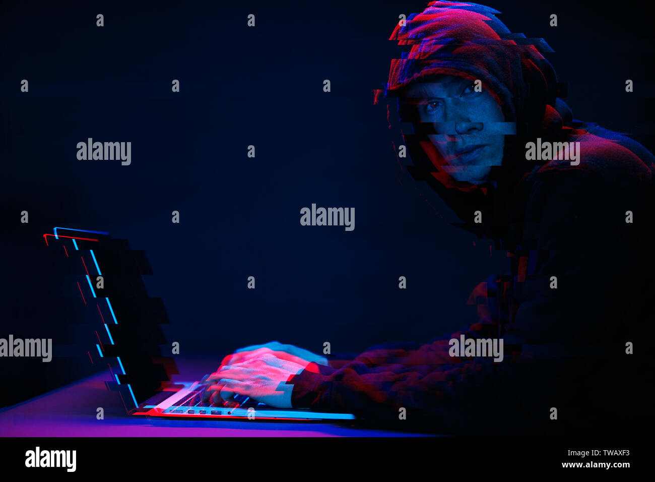 Hacker in the hood working with laptop typing text in dark room. Image with glitch effect Stock ...