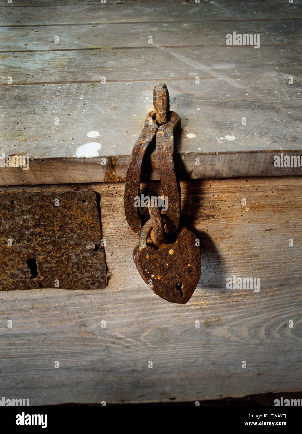 Rusty iron heart-shaped padlock on a plain oak chest. St Eilian’s ...