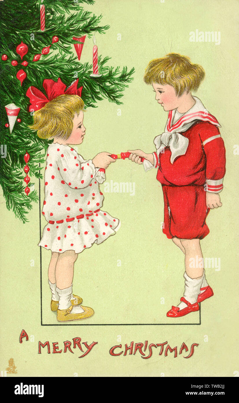 Boy and girl pulling a christmas cracker hi-res stock photography and ...