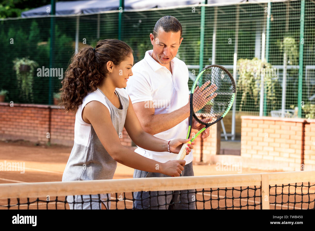 Girl teenager with long curly hair with a racket in his hands. Girl ...