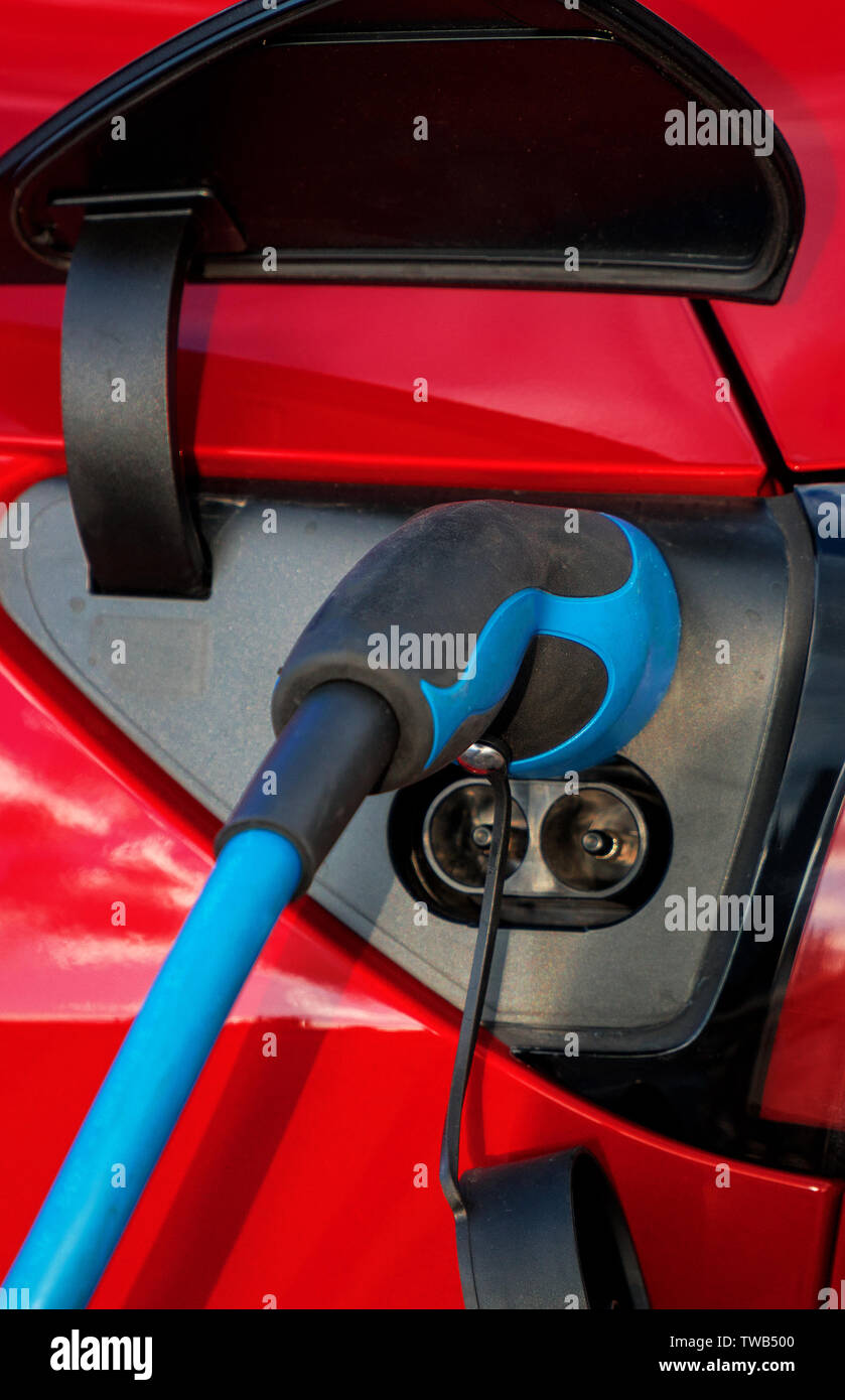 Electric plug charging red sports electric car Stock Photo - Alamy