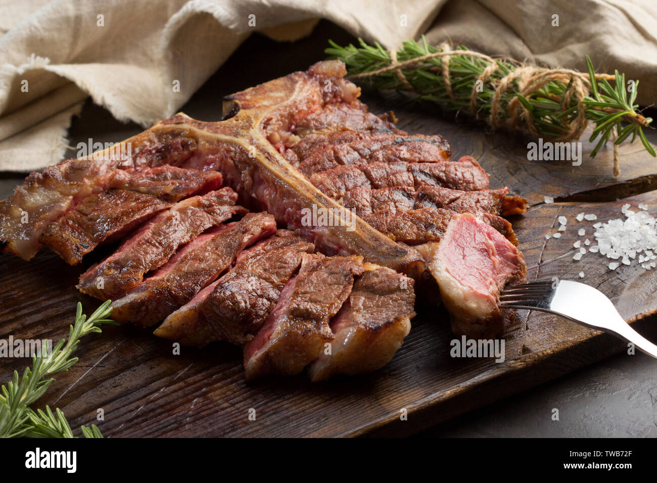porterhouse steak is grilled sliced on a piece of wood Board. rustic ...