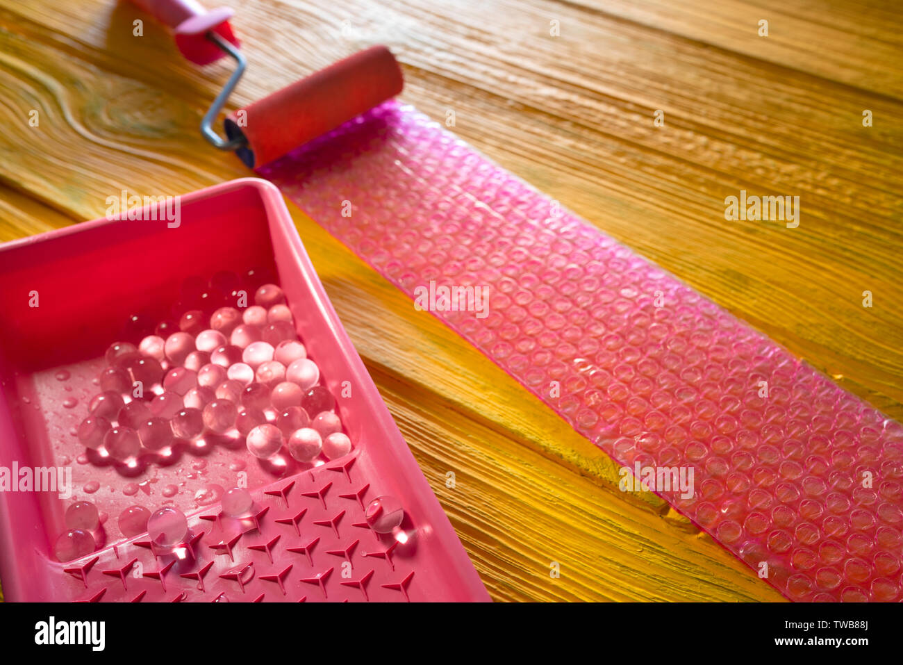 Pink paint roller and bucket abstract concept with bubble plastic track ...