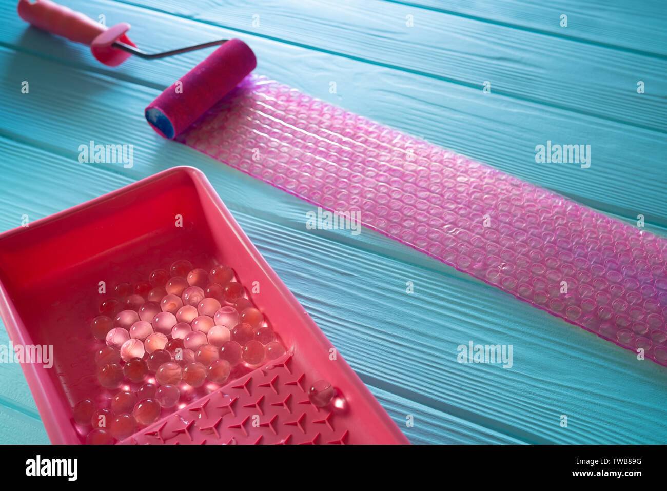 Pink paint roller and bucket abstract concept with bubble plastic track ...