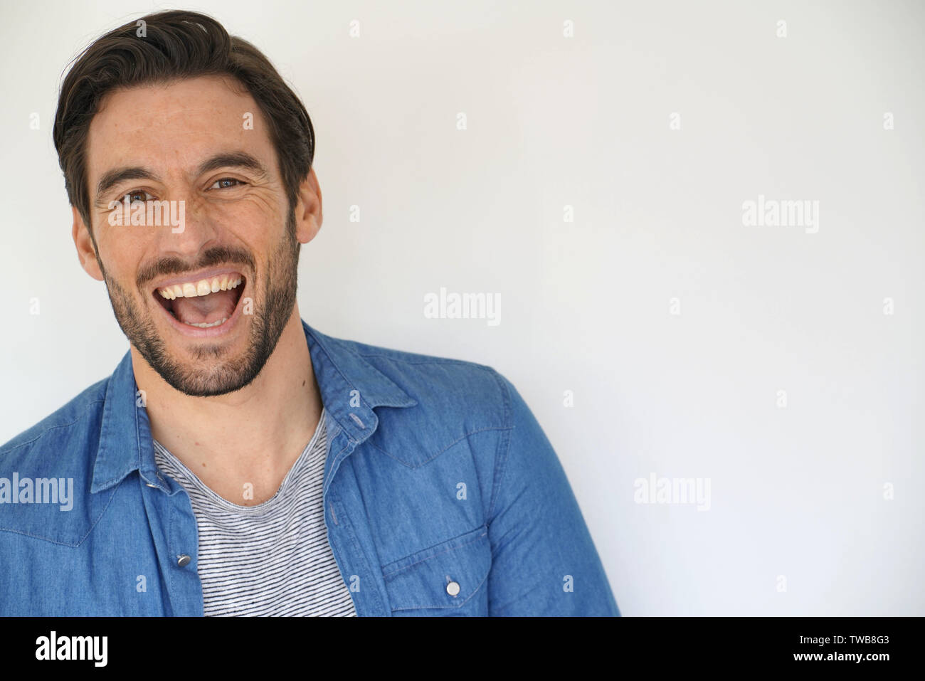 Portrait of casual laughing handsome man on white background Stock ...