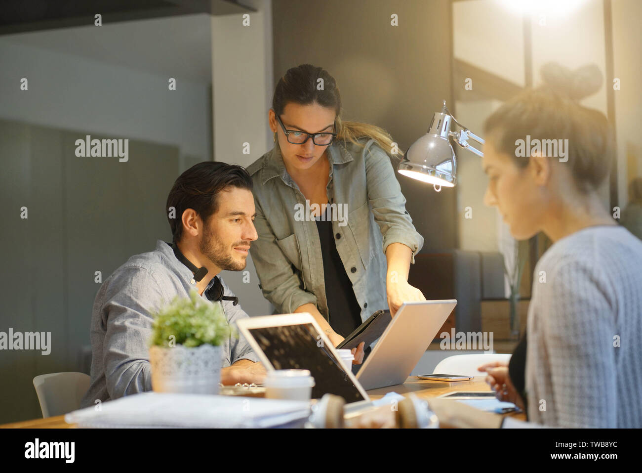 Business partners going over project in co working space Stock Photo ...