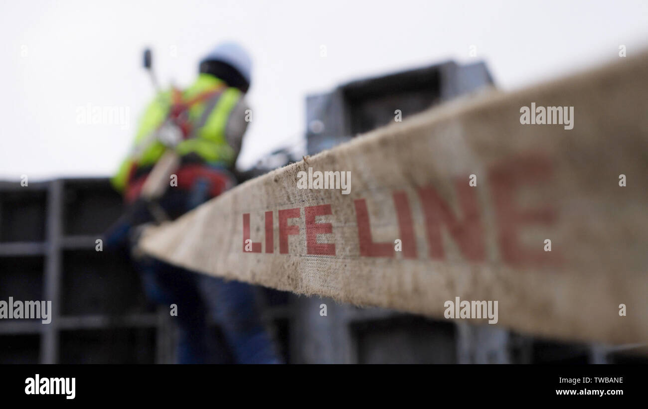 Construction worker connected with a safety harness to a life line ...