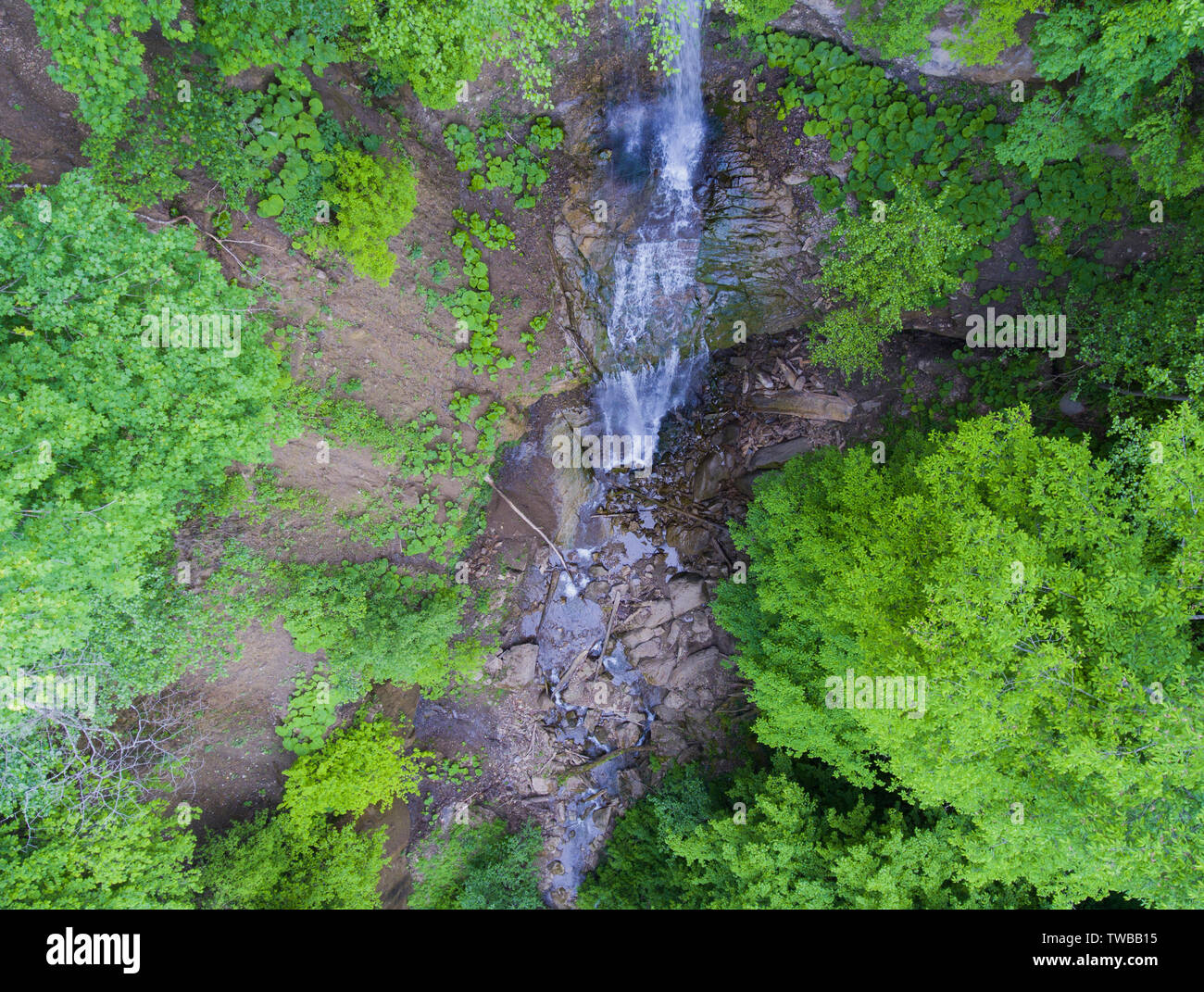 Long the flow of the waterfall cascading from the cliff. Aerial view ...