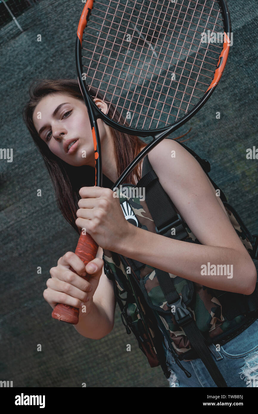 Adorable woman holds a tennis racket, fashionable model, with long ...