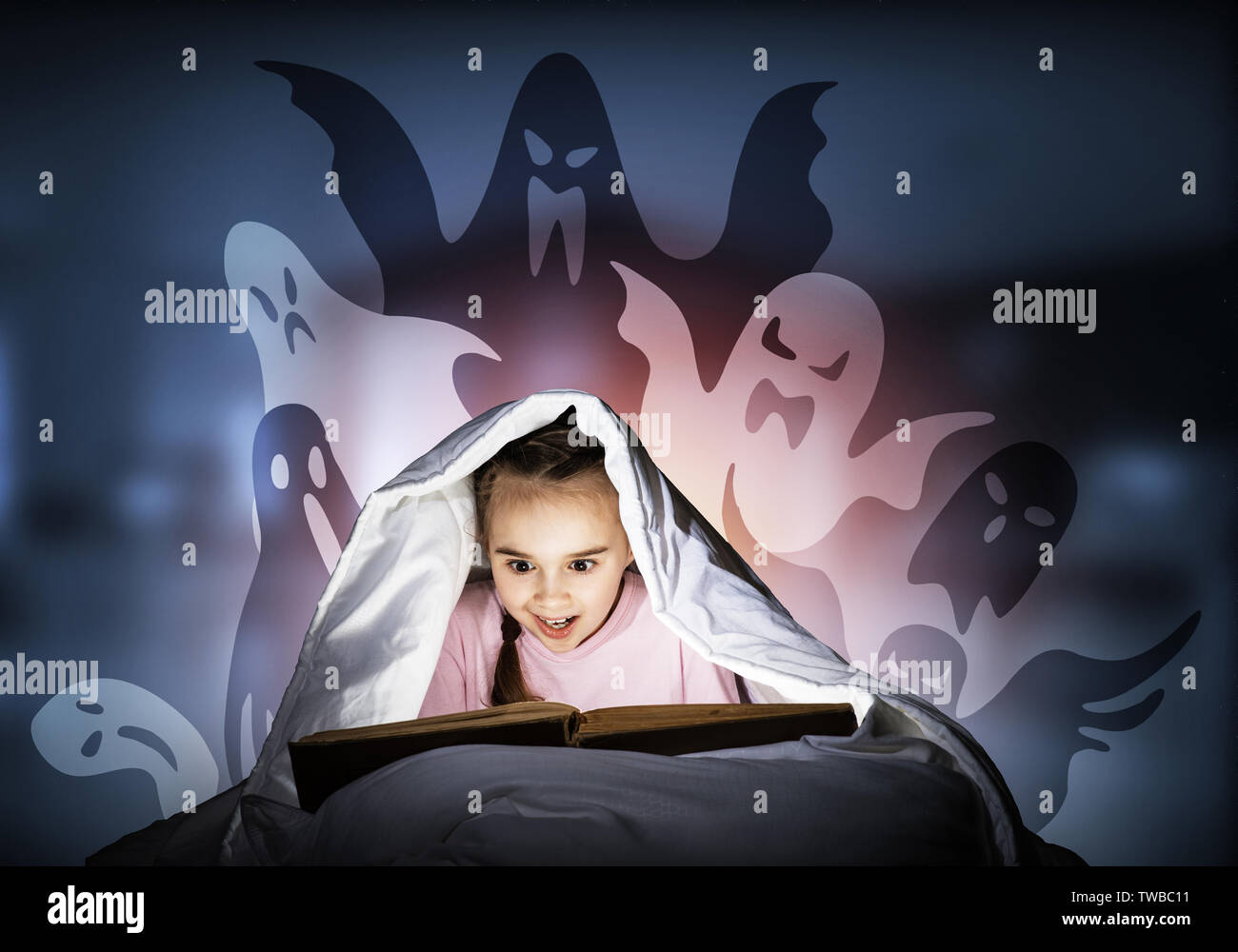 Enthusiastic little girl reading book in bed after bedtime. Kid in ...