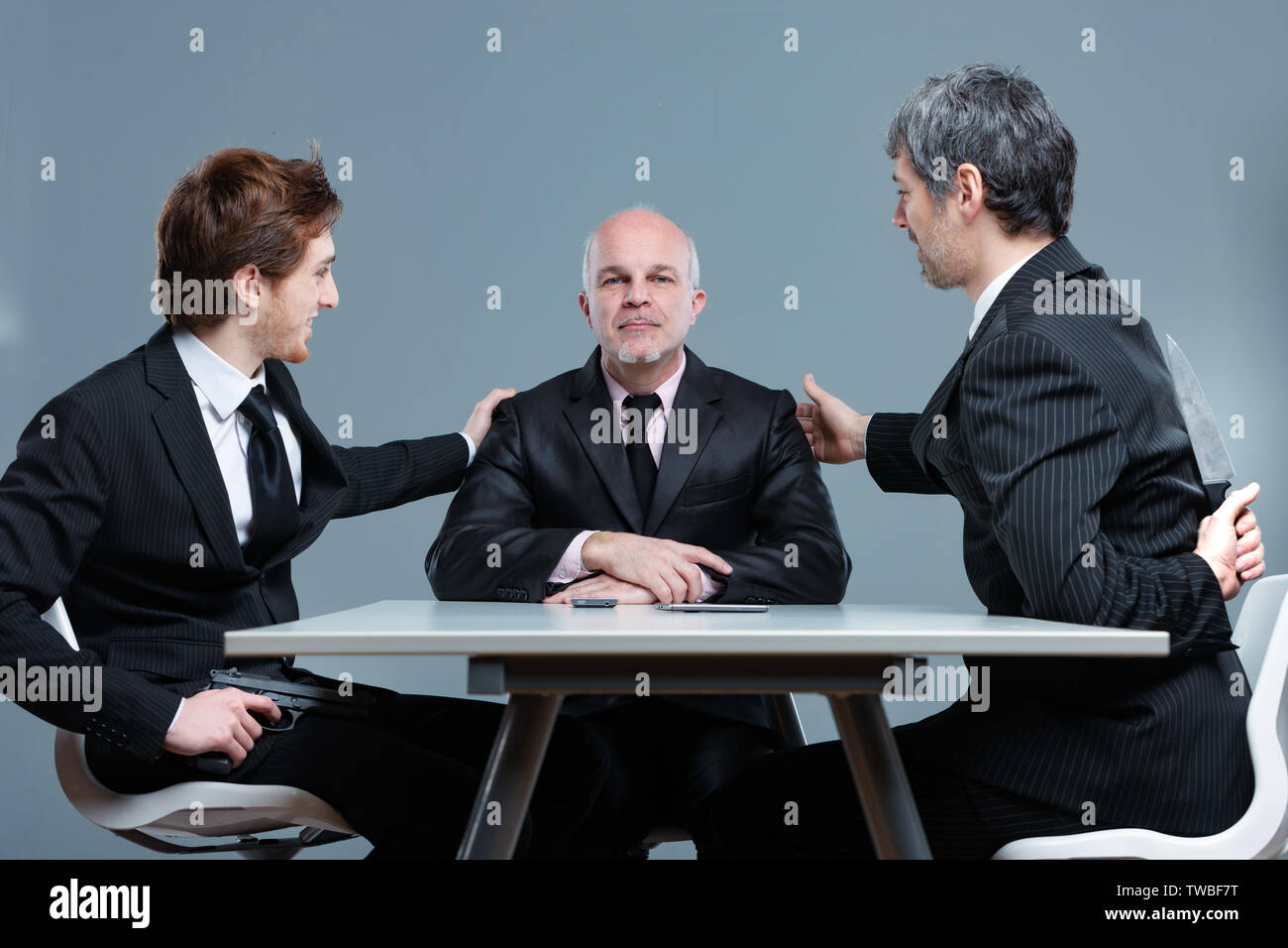 Two ambitious businessmen supporting their boss touching him on the ...