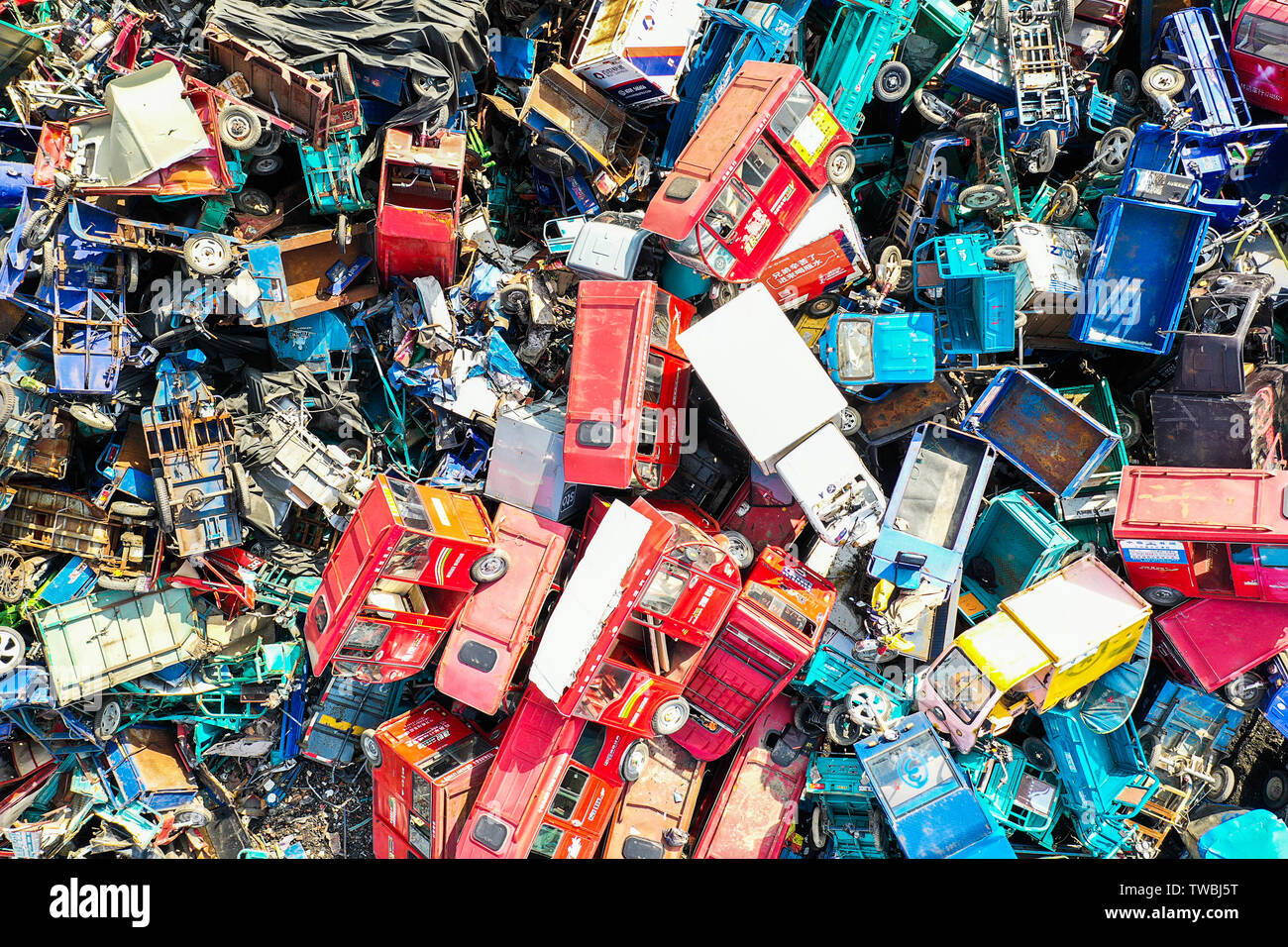 Piled together, scrap-out old motor vehicles waiting to be dismantled ...