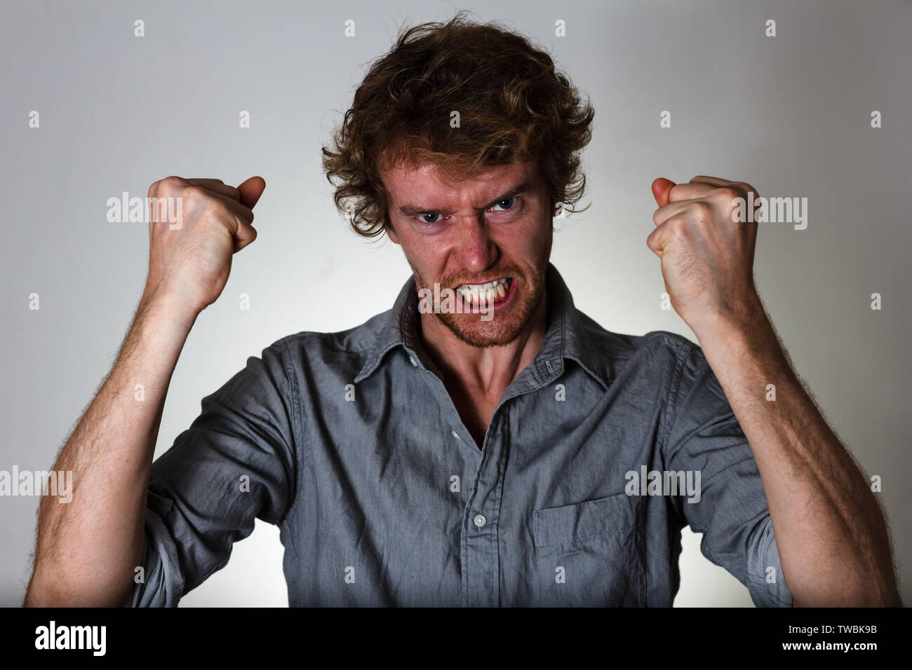 Angry young man on gray background Stock Photo - Alamy
