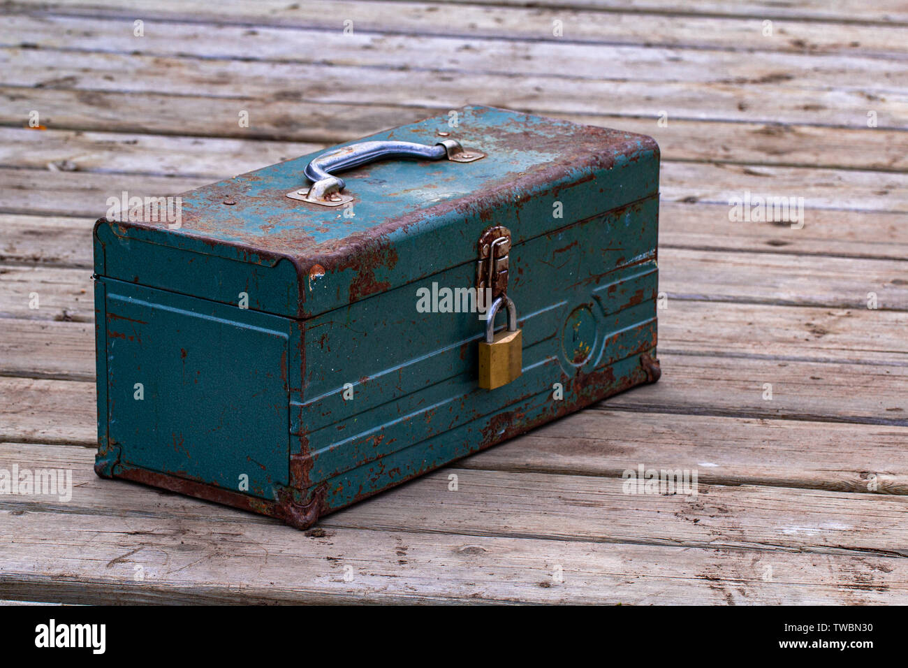 Rusty old toolbox locked up sitting on a wood Stock Photo - Alamy