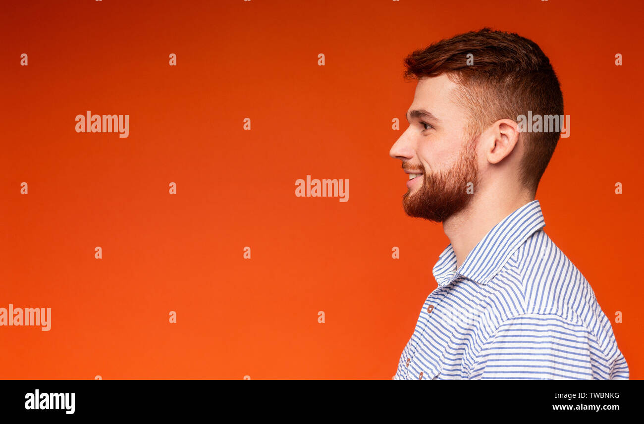 Side view portrait of smiling millennial man looking away at copy space ...
