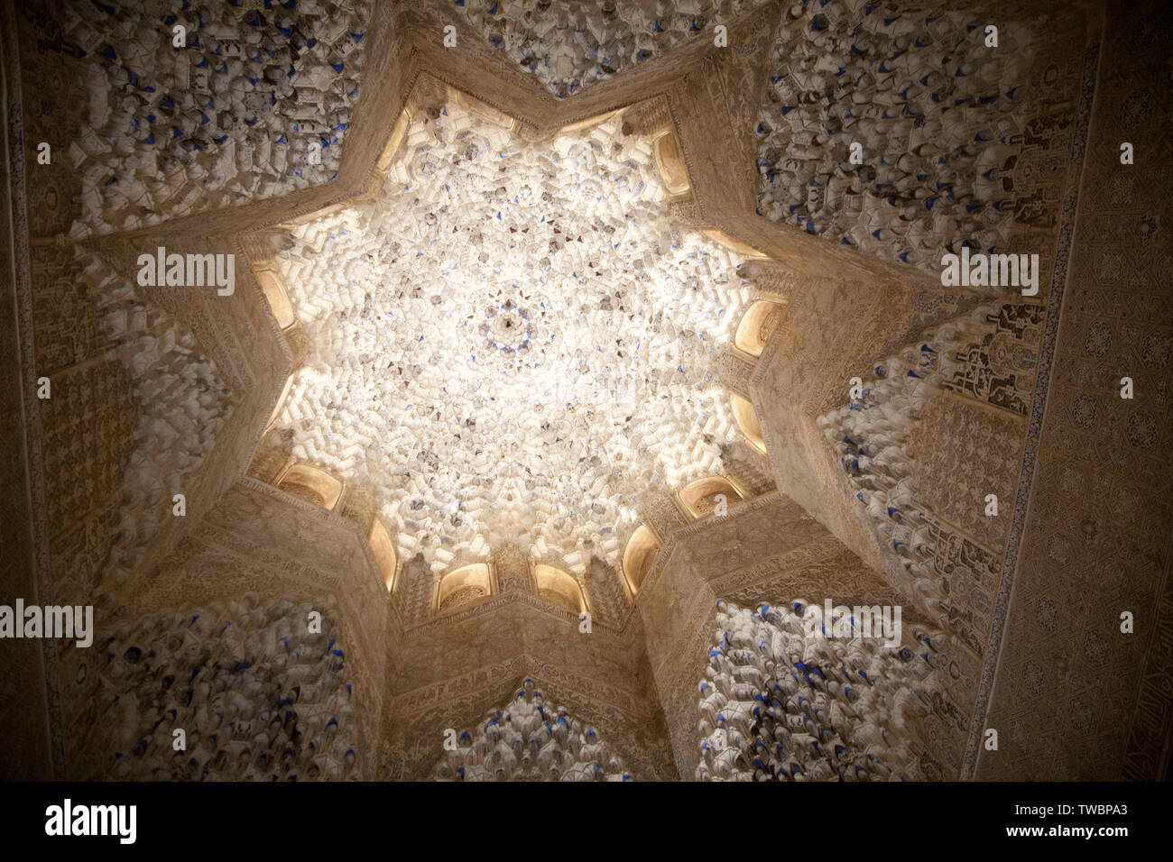 Illuminated view at night of richly decorated Islamic stonework ceiling ...