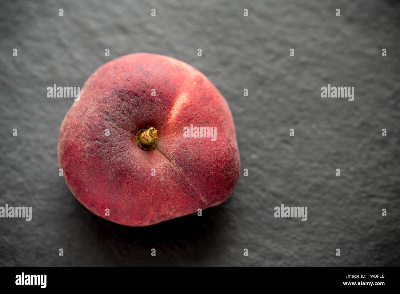 A flat peach imported from Spain and bought from a supermarket in the ...