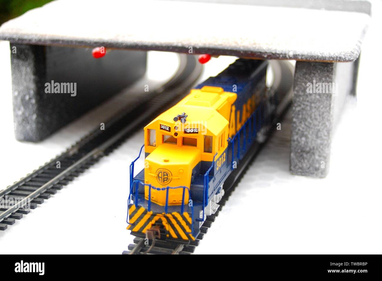 Model railroad train on tracks passes through shelter (Alaskan Snow ...