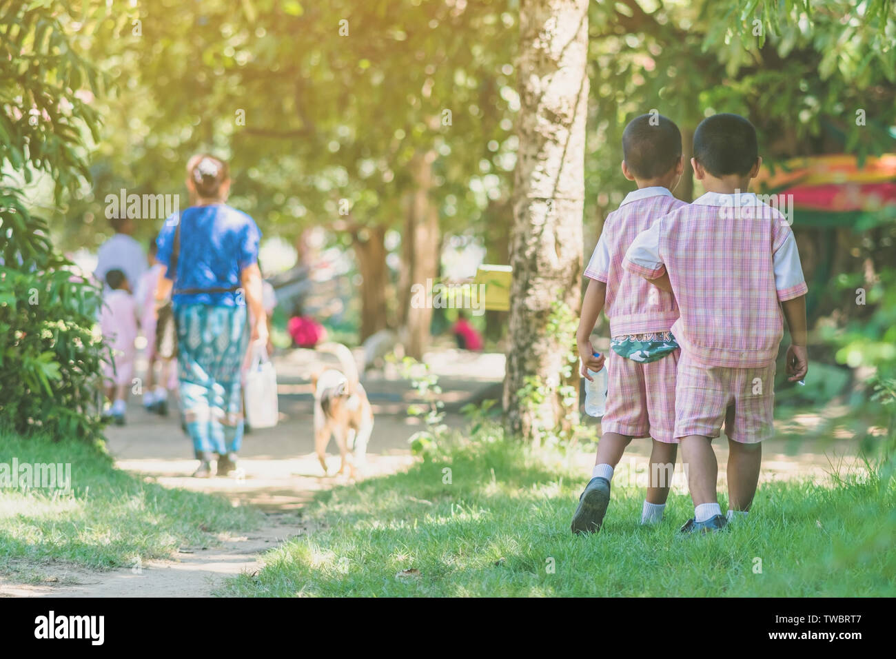 Kindergarten boy walk after female teacher and his friends back to ...