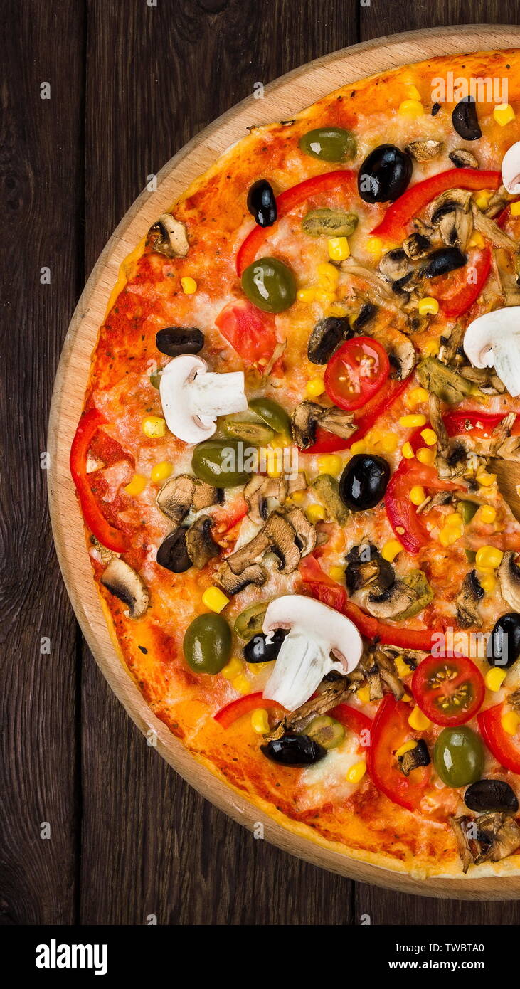 Italian pizza with ham, tomatoes and black olives on wood, top view ...