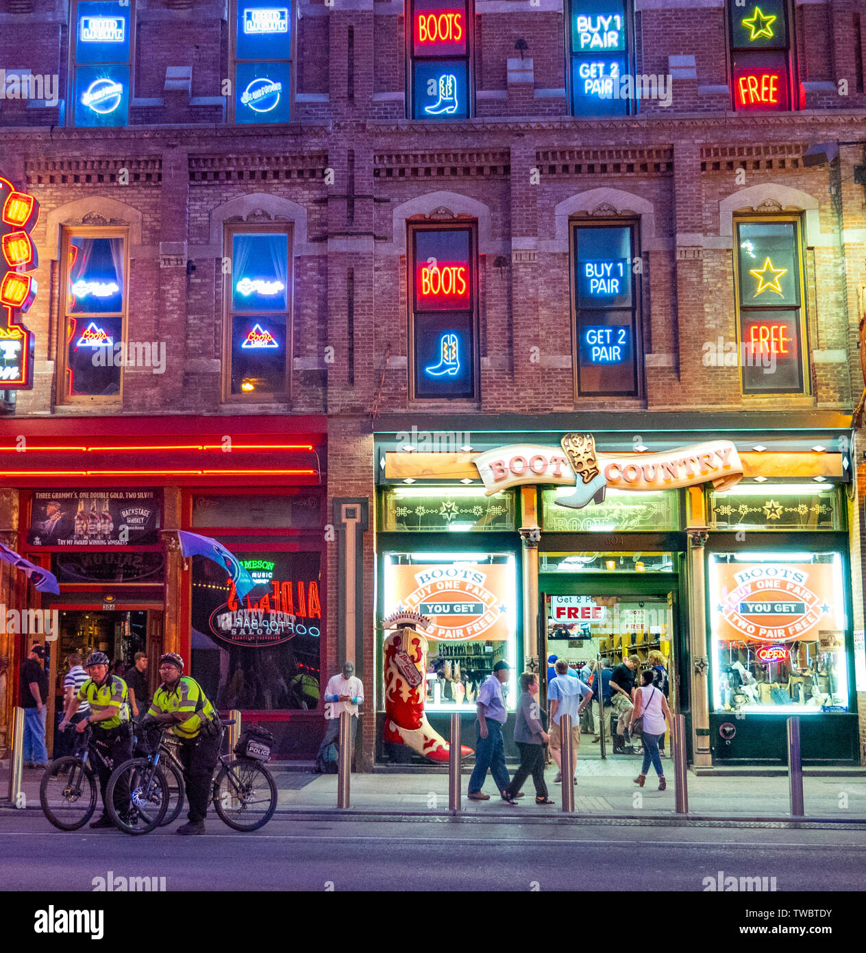 NFL fans and tourists walking along Broadway and neon signs lit up at ...