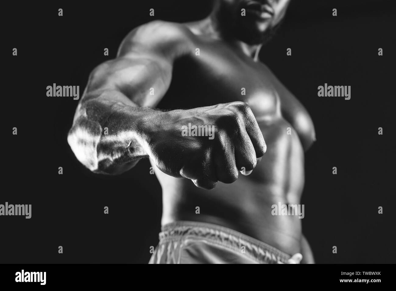 Muscular african bodybuilder demonstrating his fist and vein, black and ...