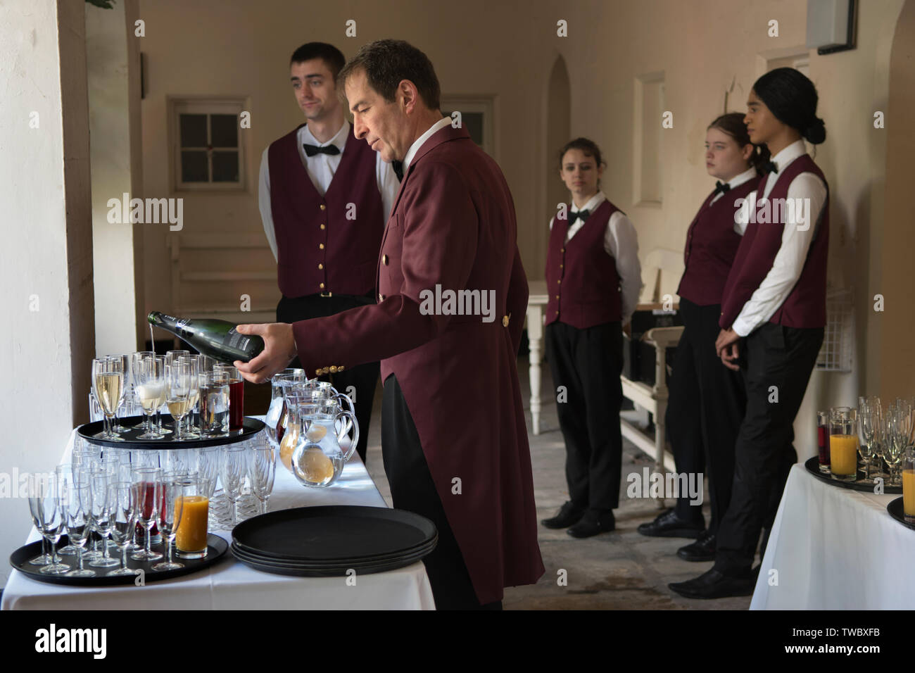 Pouring champagne, Maître d' the head waiter holds the bottom of the Champagne bottle pours ...