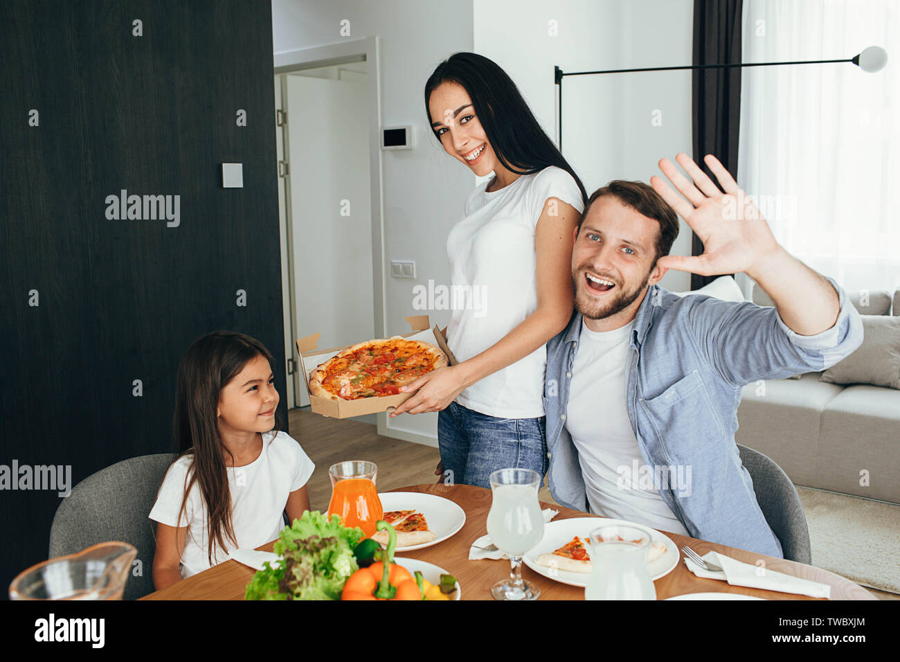 Family enjoying pizza lunch. Father, mother and daughter during dinner ...
