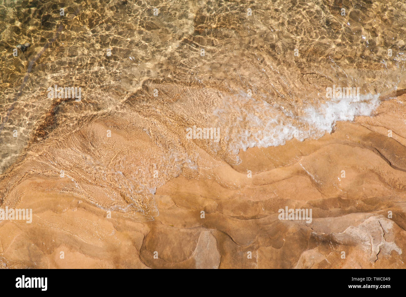 looking straight down into the crystal clear waters and sandstone at ...