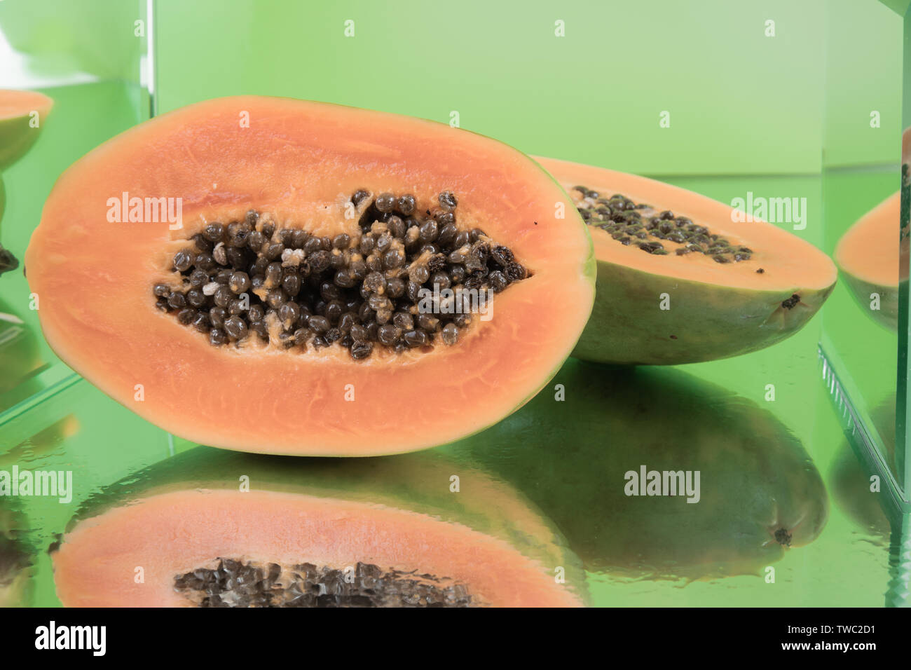 Fresh papaya on mirror background with full reflection. Orange pulp and ...